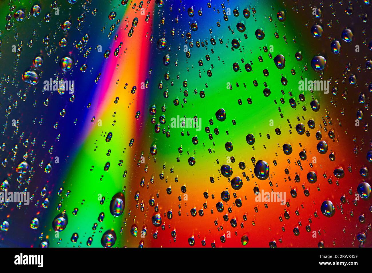 Beam of light across abstract rainbow colored background with rain ...