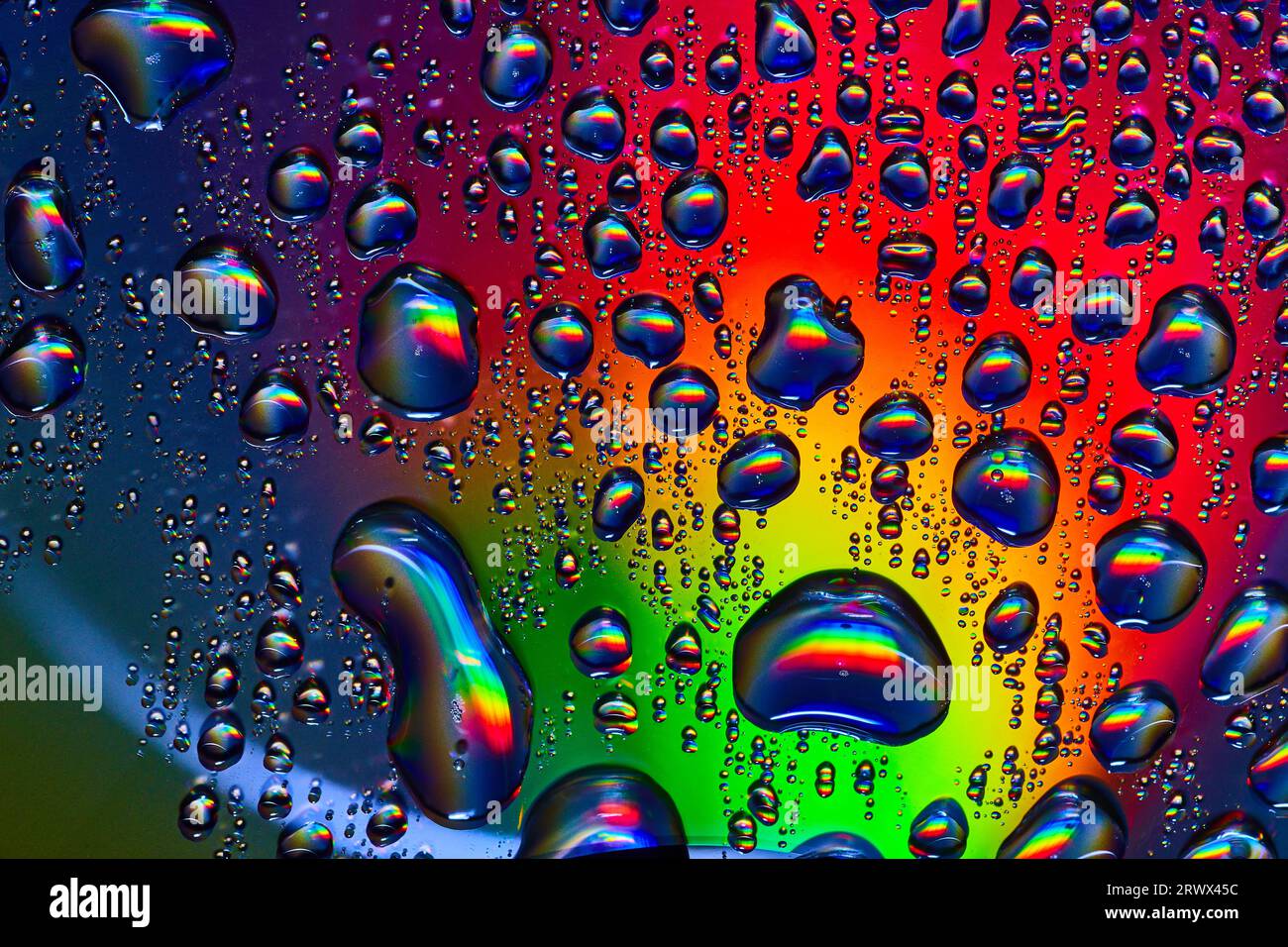 Fizzy odd shaped bubbles bursting across rainbow colored metallic ...