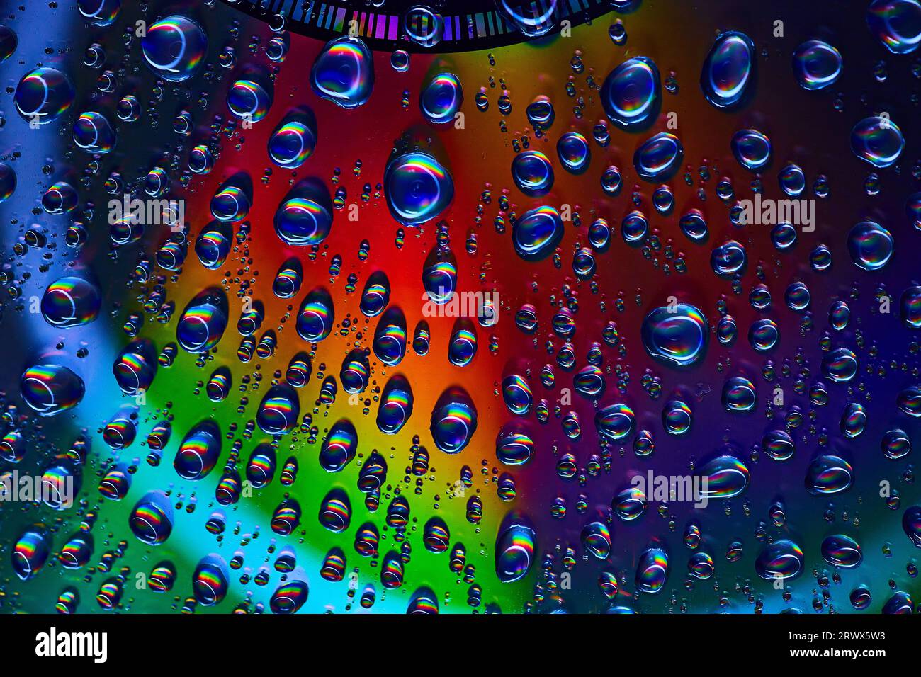 Dark and colorful metallic surface with bubbles on abstract CD surface ...