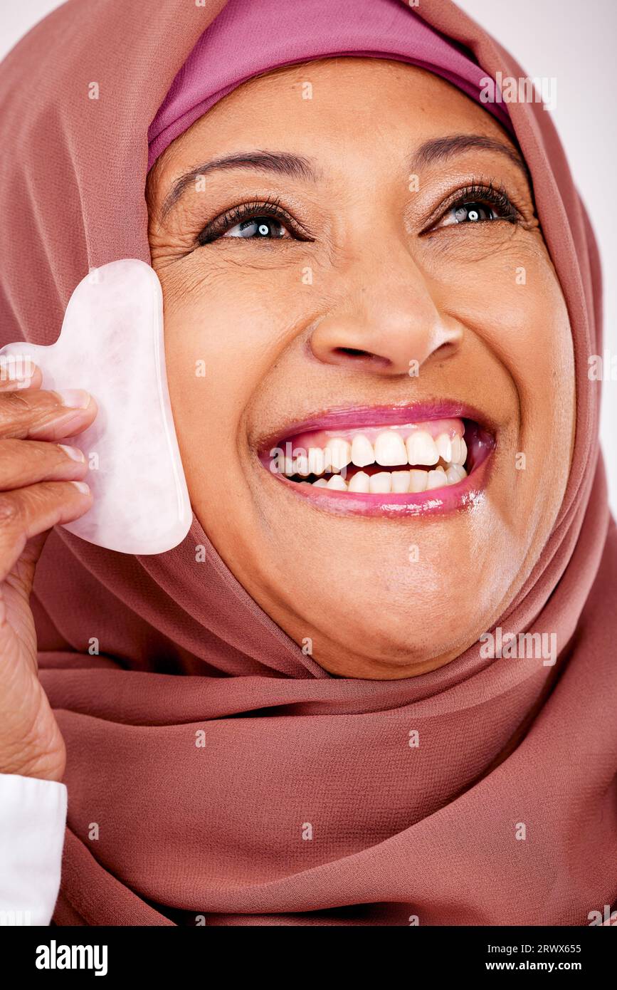 Skincare, gua sha stone and face of muslim woman closeup in studio on a ...