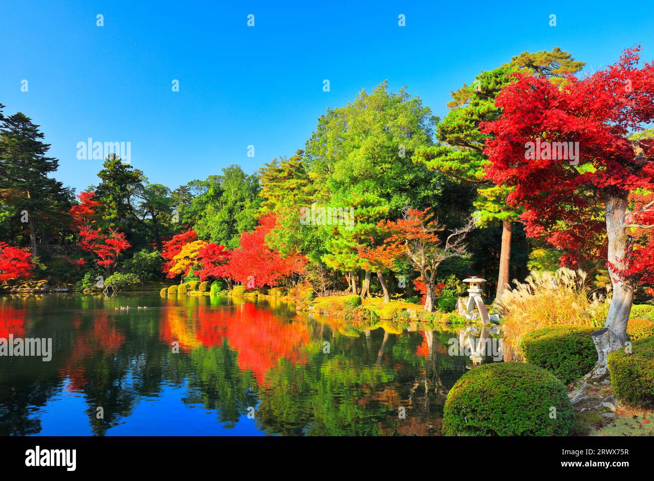 Autumn leaves on the koji lantern and Kasumigaike Pond at Kanazawa ...