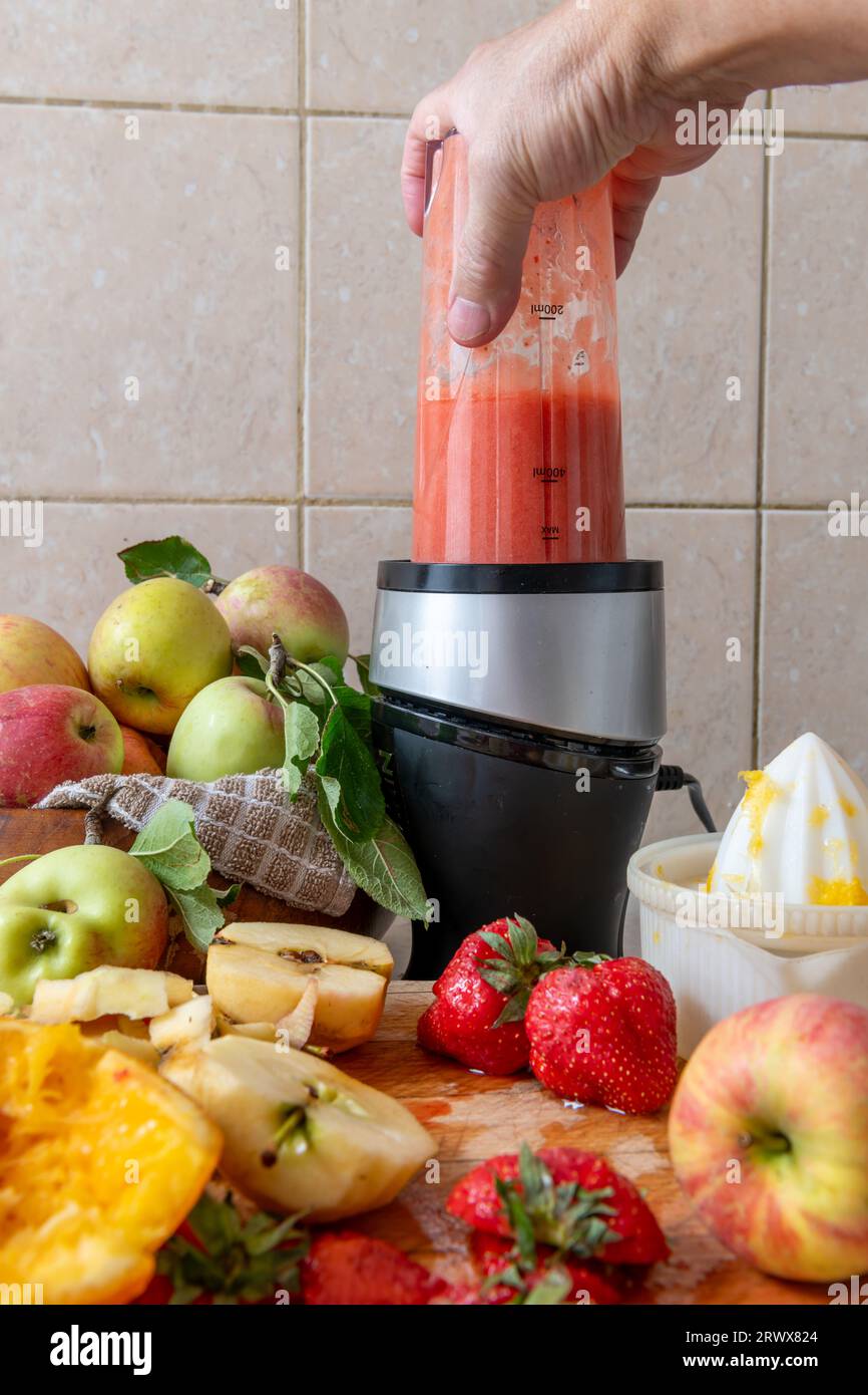 Making a smoothie with fresh fruits in a blender. Healthy life style ...