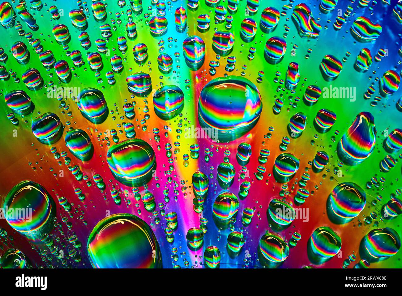 Brilliant burst of rainbow colors in water drops in abstract background ...