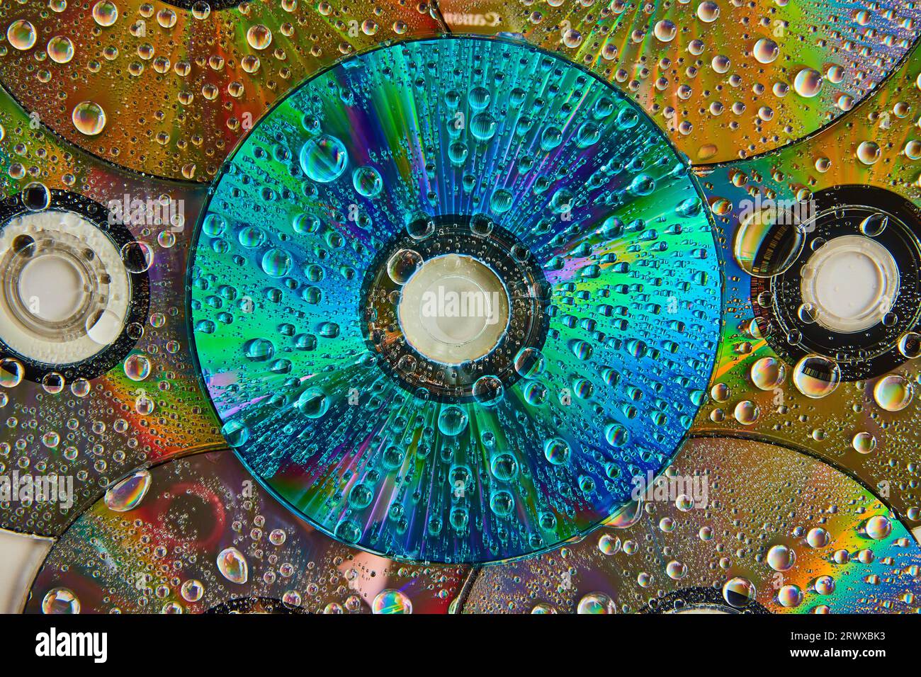 Colorful and vibrant blue CD surface with water drops stacked on top of ...