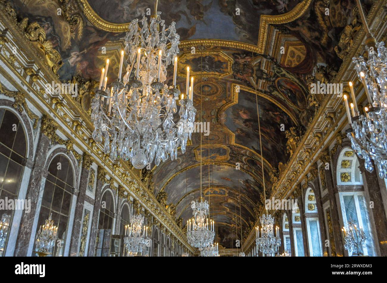 A chandelier hanging from the painted ceiling of the Hall of Mirrors ...