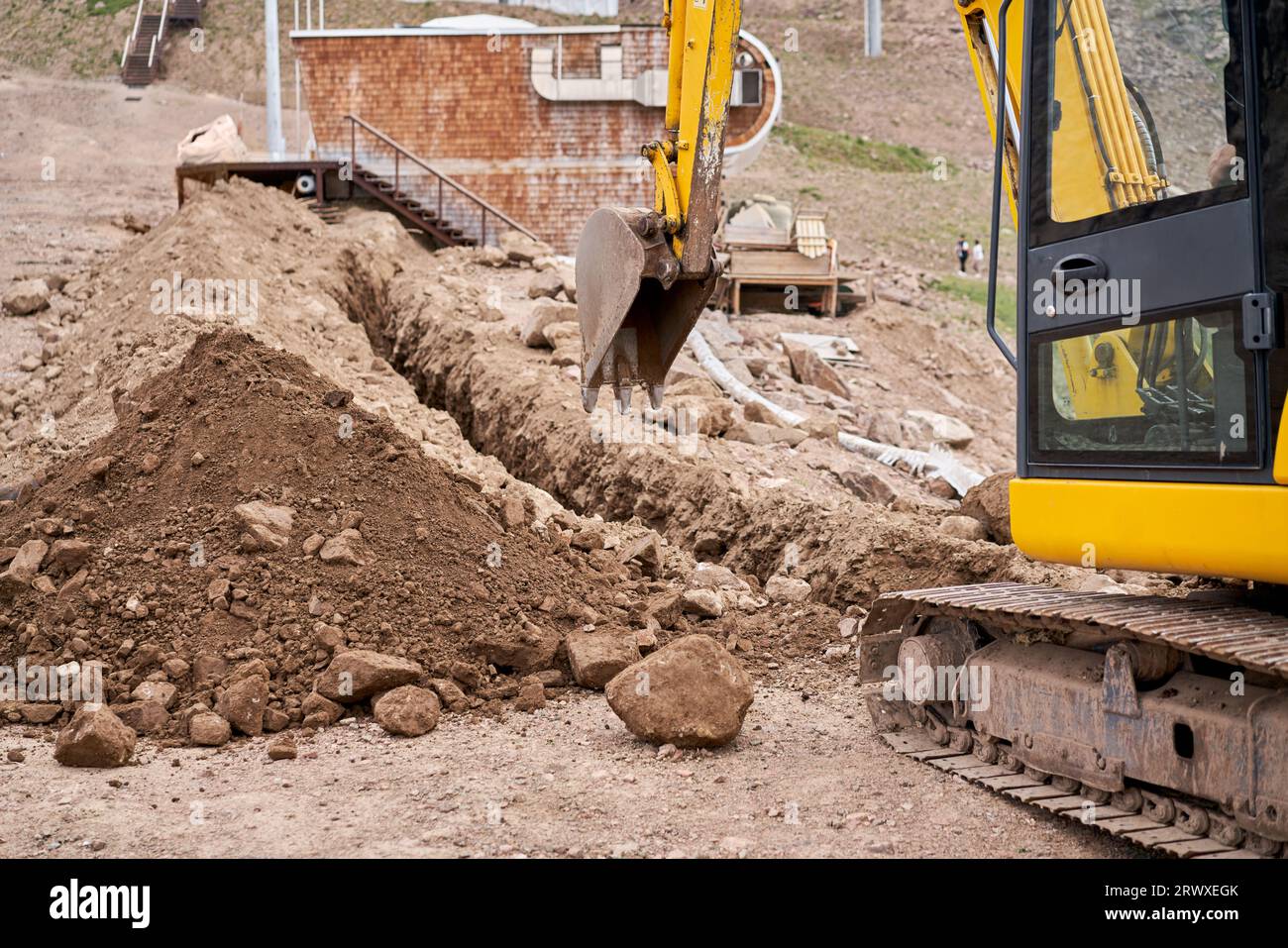Excavator works in the highlands. Makes a trench for communications ...