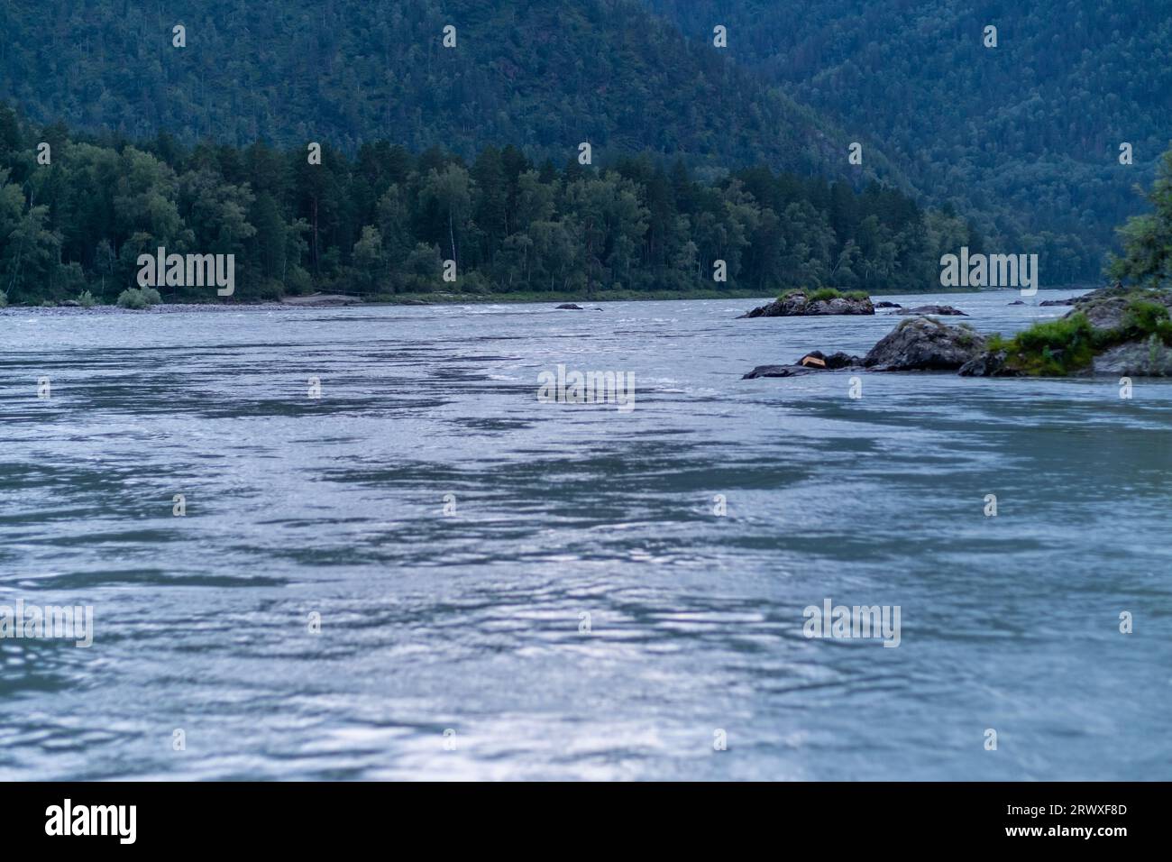 A wide, full-flowing mountain river with a fast current Stock Photo - Alamy