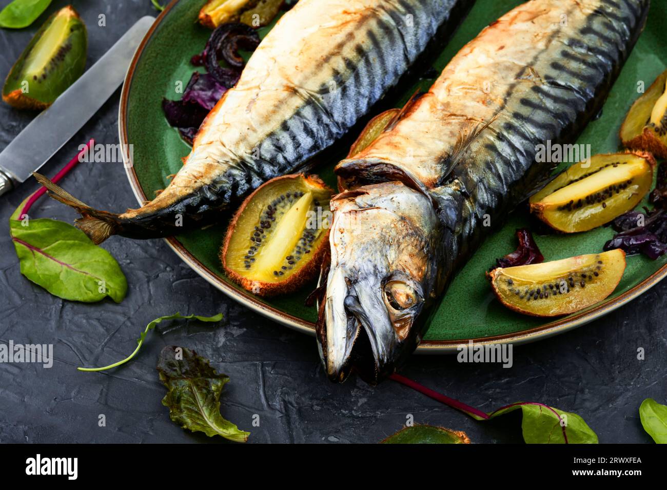 Two mackerel fish roasted with kiwi pieces Stock Photo - Alamy