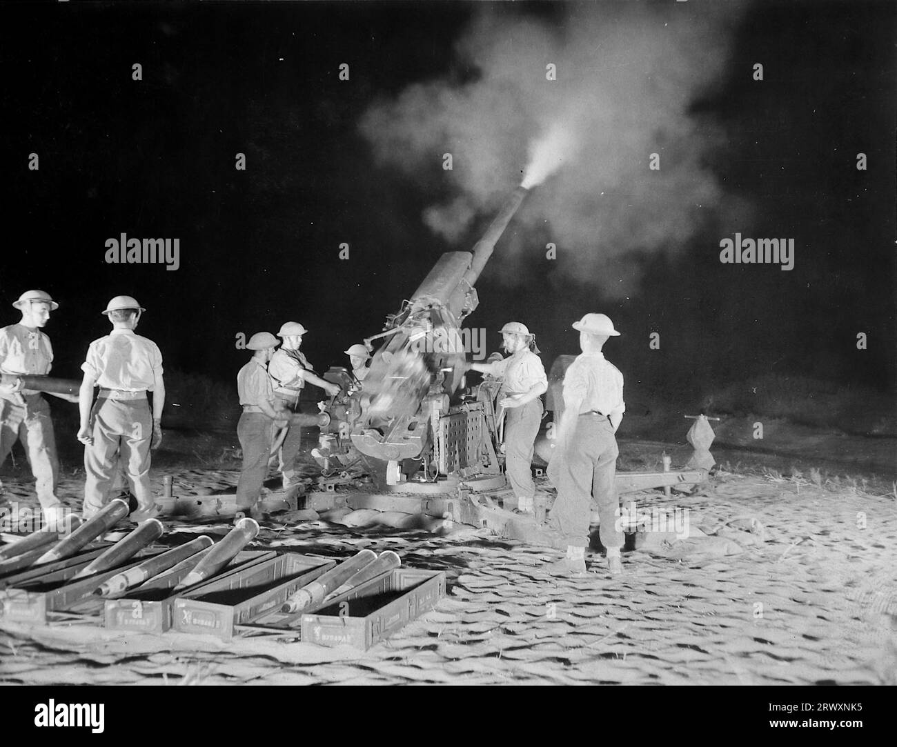 Night time demonstration of a British anti-aircraft gun with its crew ...
