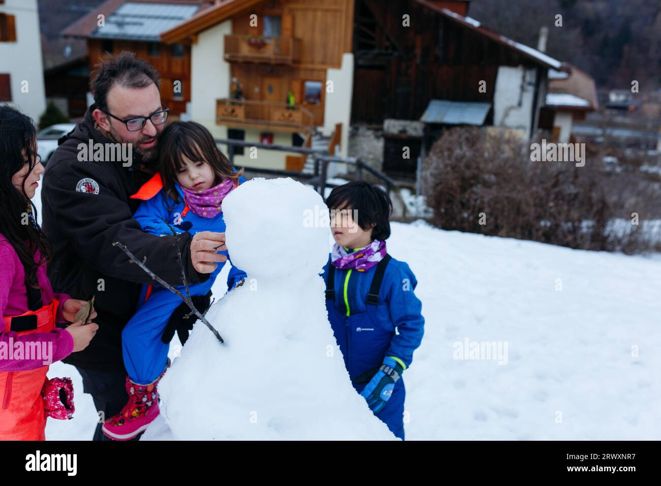 father with three children making snowman outdoors Stock Photo - Alamy