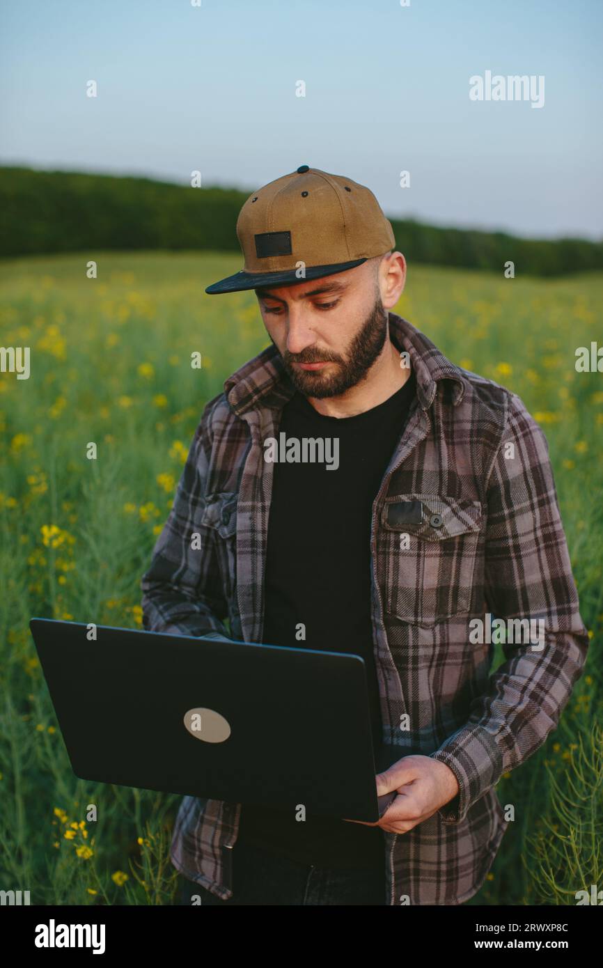 Successful farmer with his field. Using smart technology for growing ...