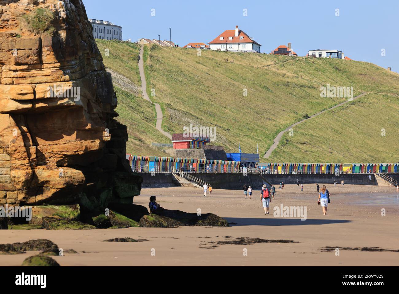 Colourful beach huts on the West Cliff beach in Whitby, North Yorkshire ...