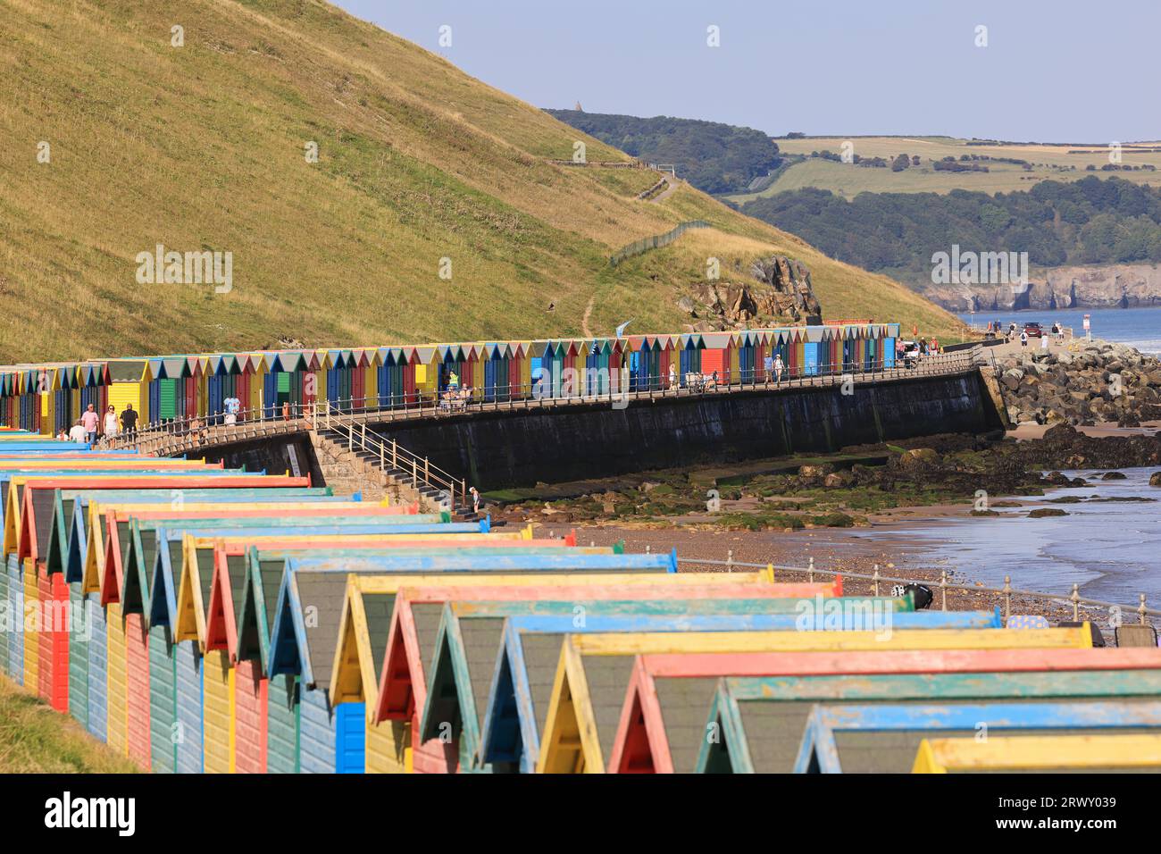 Colourful beach huts on the West Cliff beach in Whitby, North Yorkshire ...