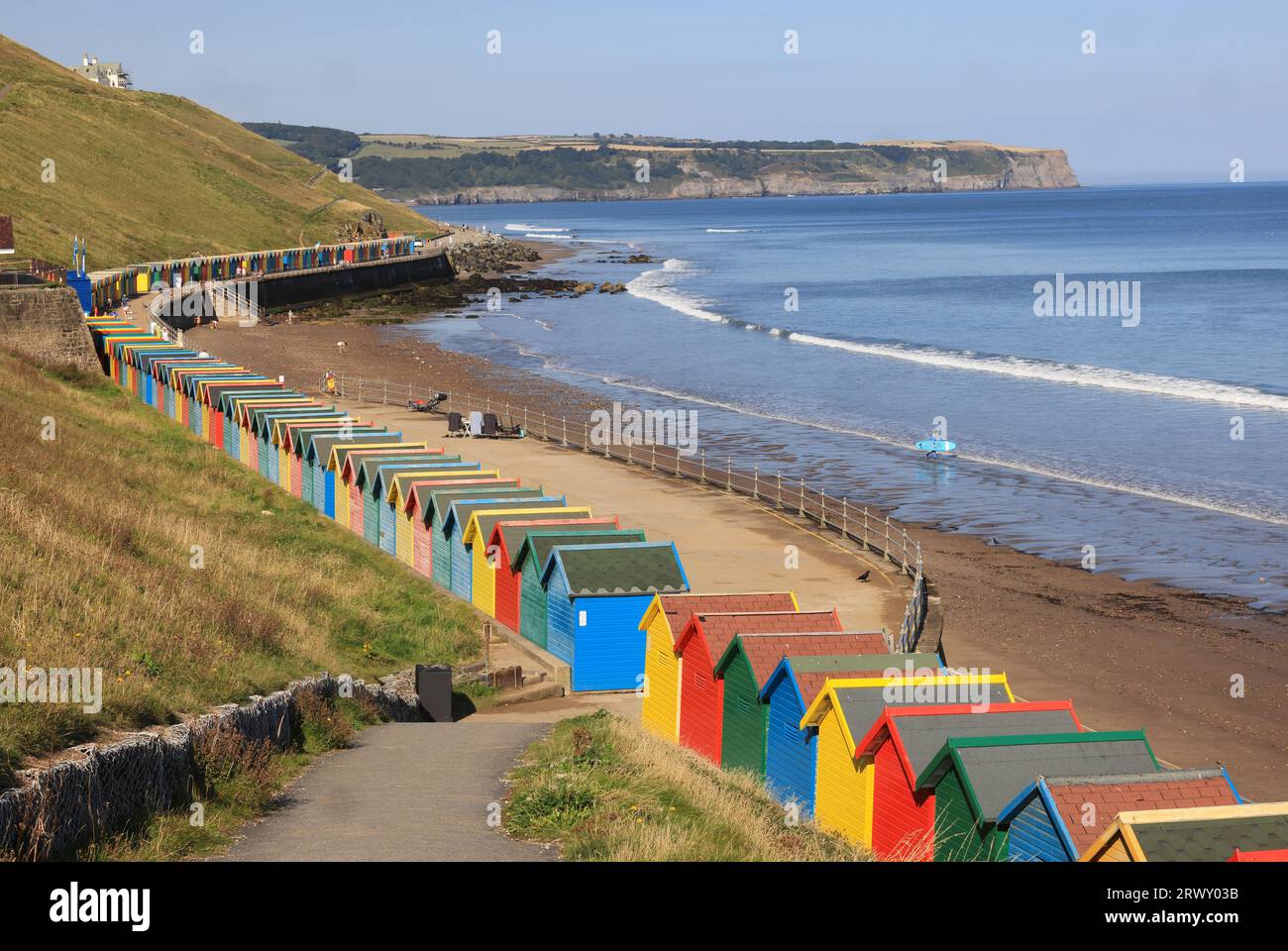 Colourful beach huts on the West Cliff beach in Whitby, North Yorkshire ...