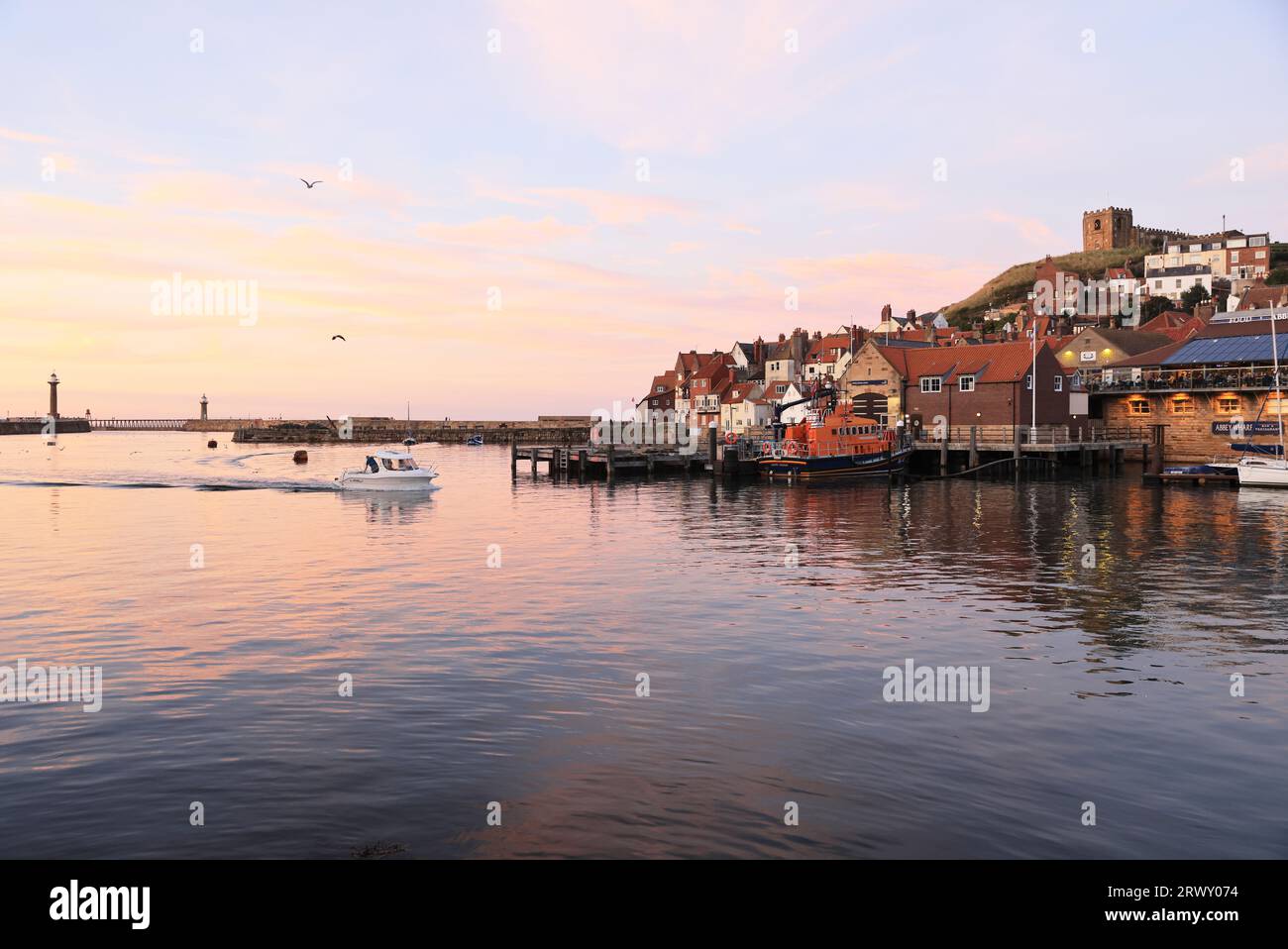 Sunset over pretty Whitby harbour on the North Yorkshire coast, UK ...