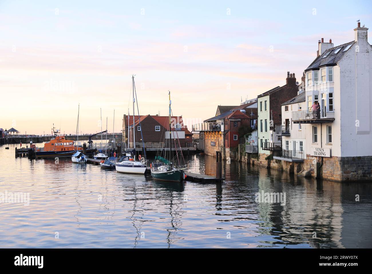 Sunset over pretty Whitby harbour on the North Yorkshire coast, UK ...