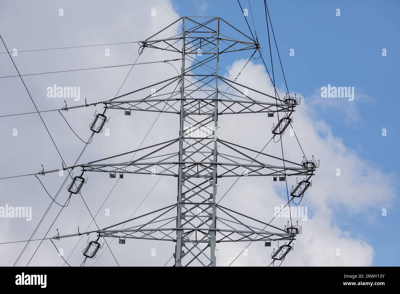 A high voltage elenctic line pole against a sky with white clouds Stock ...