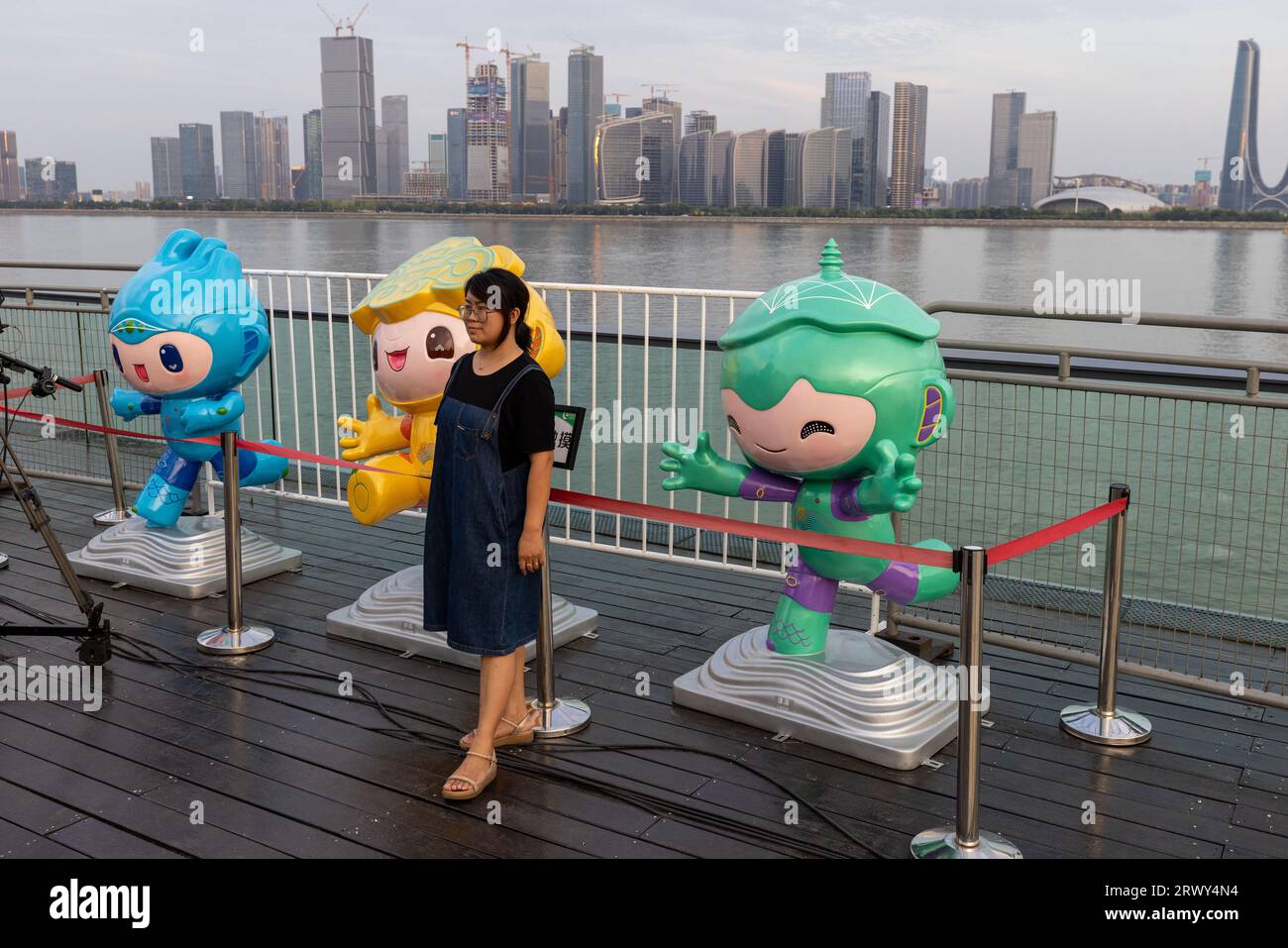 Women take picture infront mascots of the 19th Asian Games on display ...