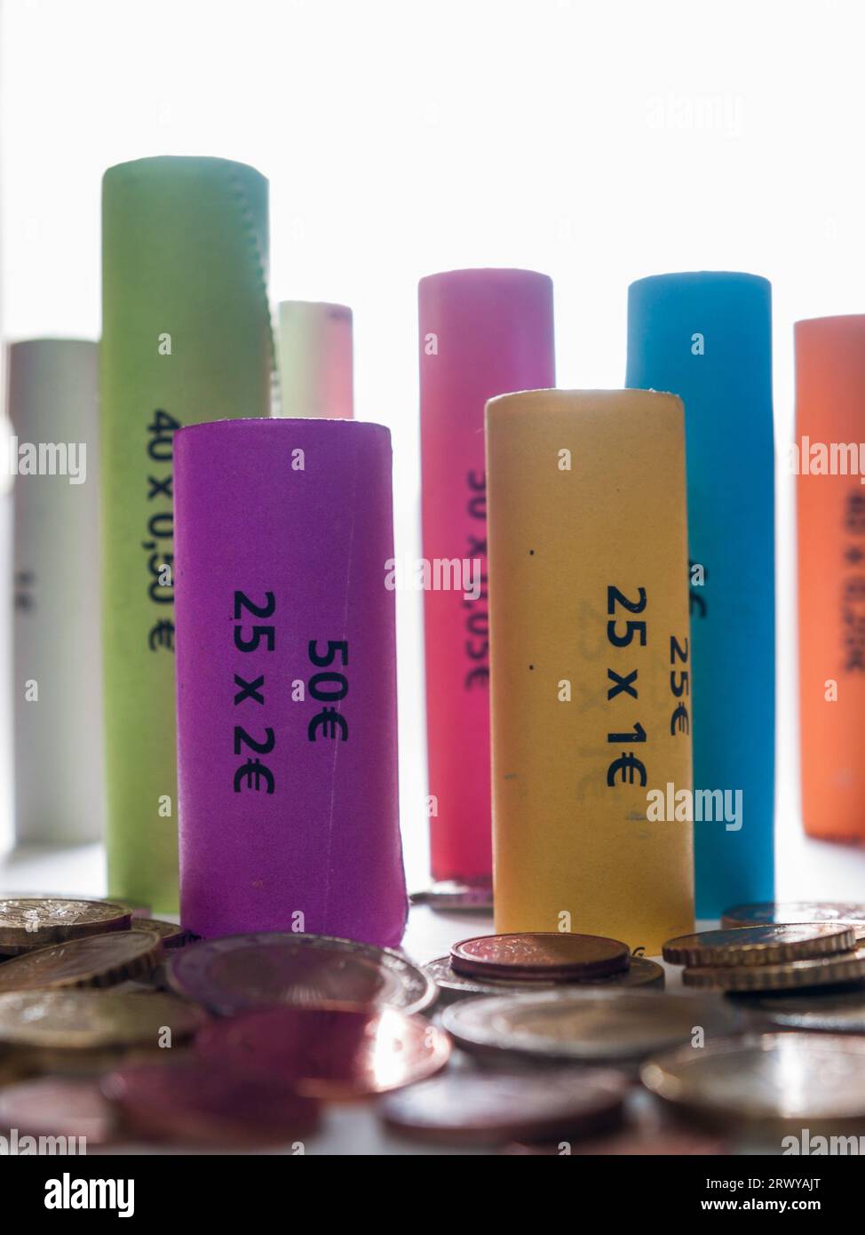 An image of an assortment of Euro coins and rolls of coins on a plain ...