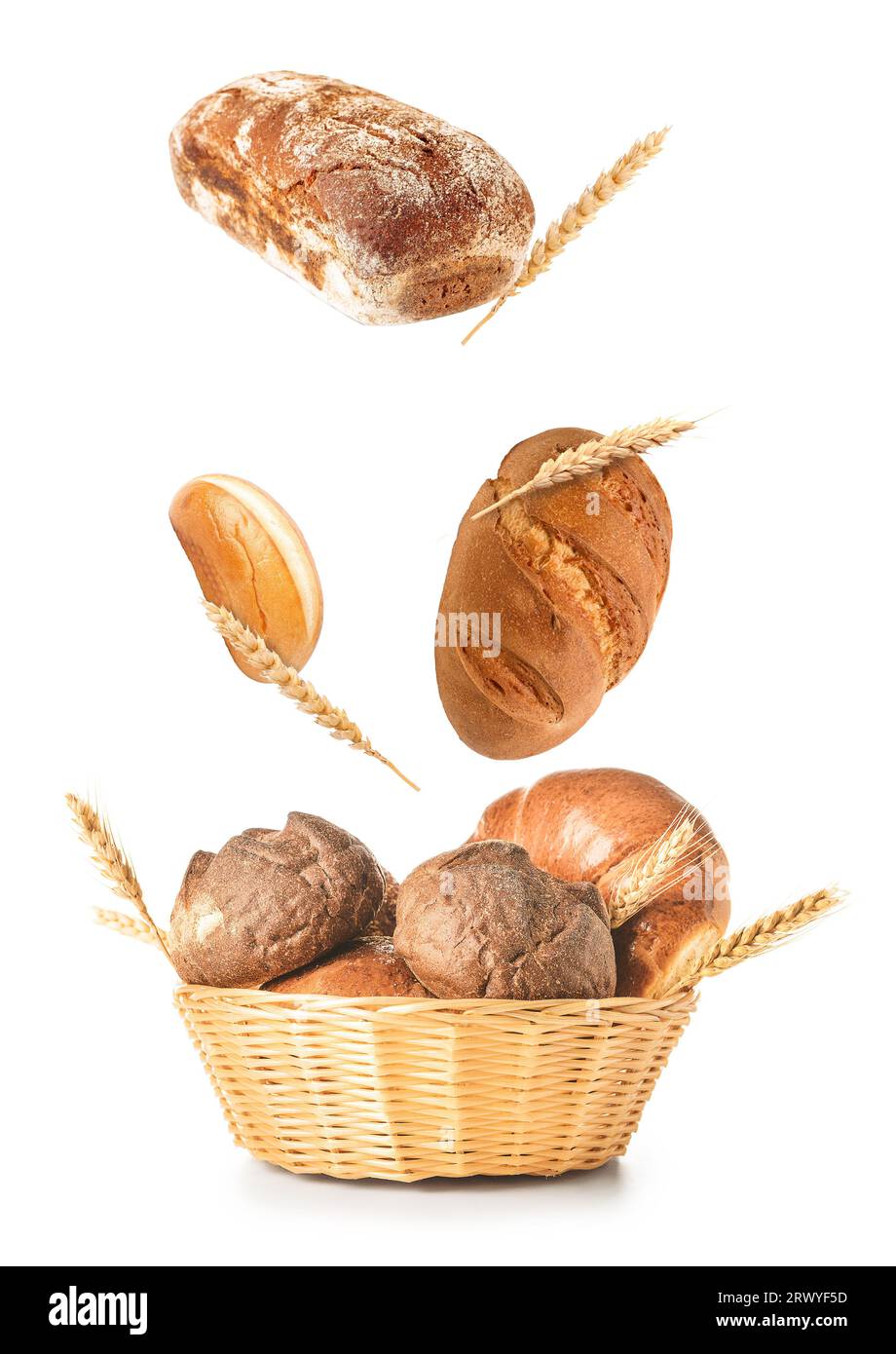Different bakery products falling into basket on white background Stock ...