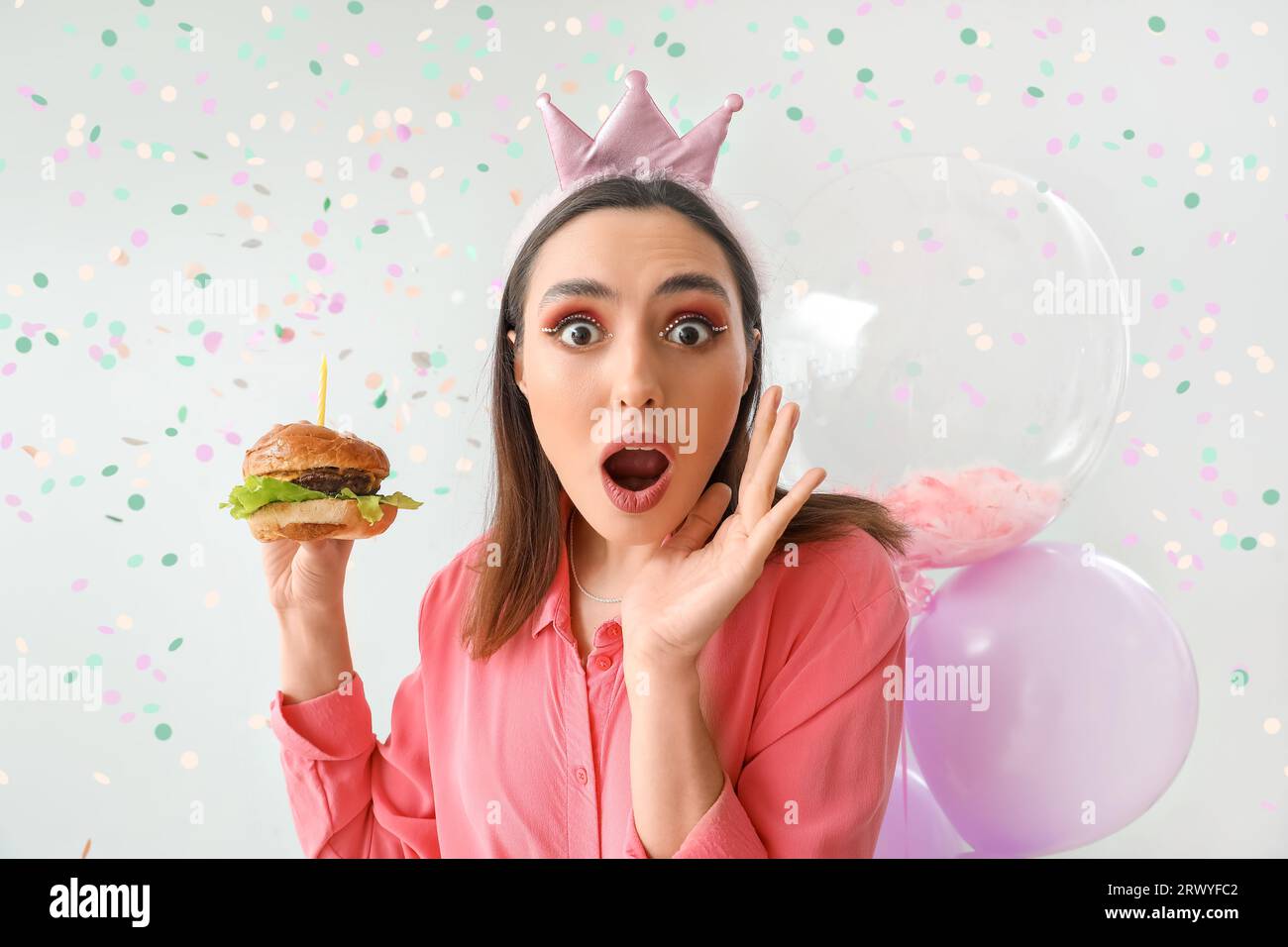 Shocked young woman with Birthday burger on grey background, closeup ...