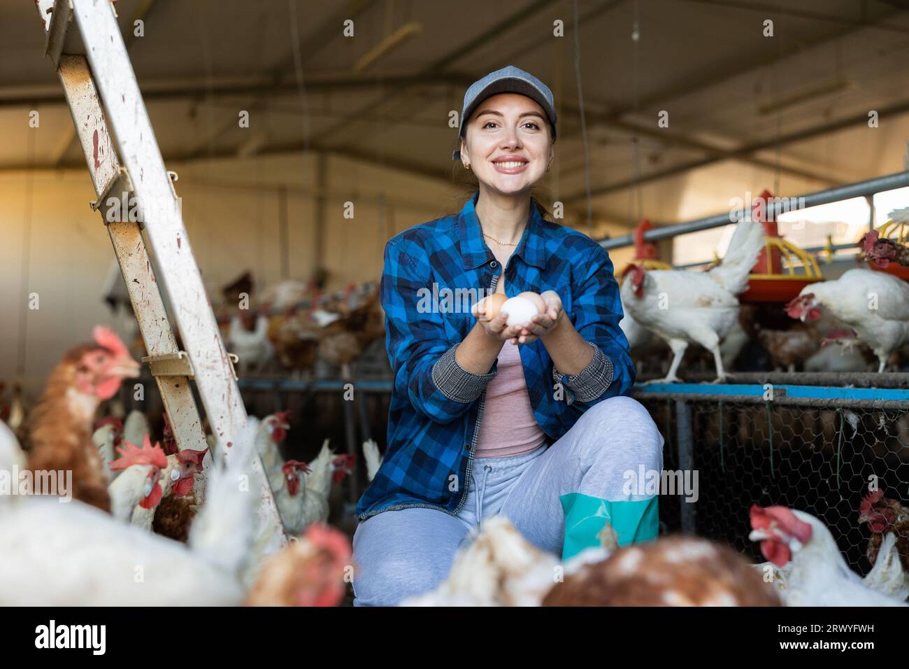 Happy female owner of poultry farm with eggs in hands posing in ...