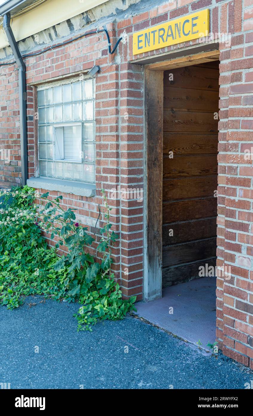 ENTRANCE sign at open door of red brick commercial building shows a ...