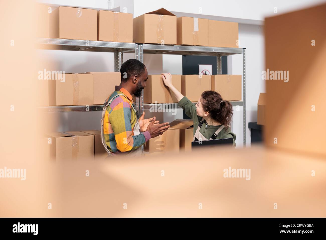 Multi ethnic storehouse team checking cardboard boxes, working at ...