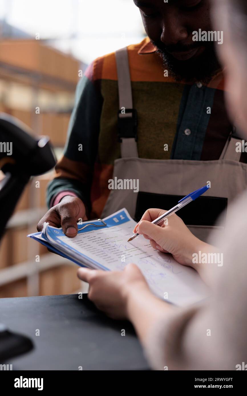 Supervisor signing merchandise quality control report, discussing ...