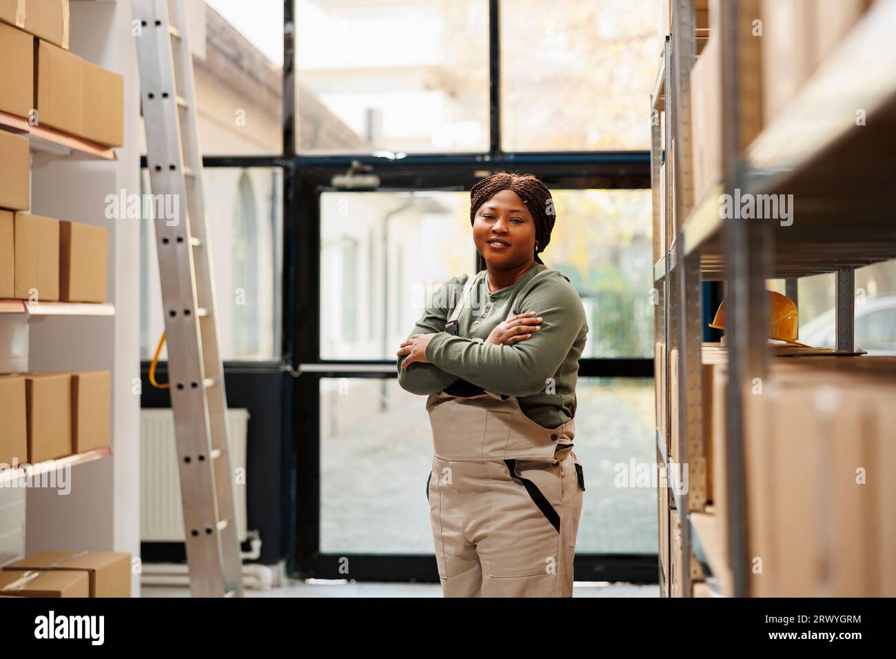 Storehouse manager standing in delivery department posing with arm ...