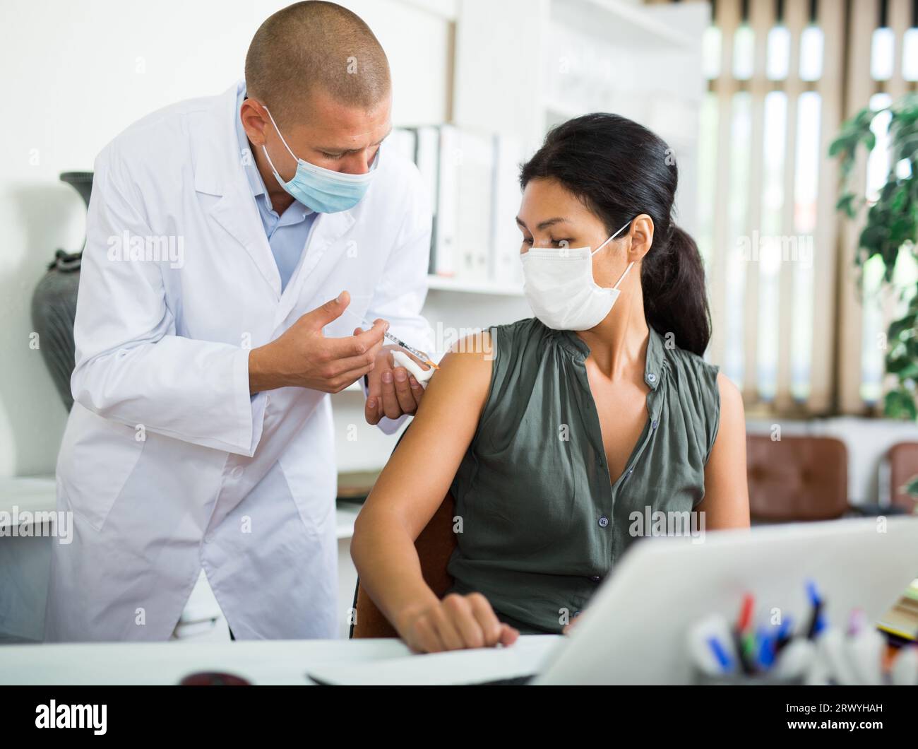 Female office employee getting antiviral injection at workplace Stock ...
