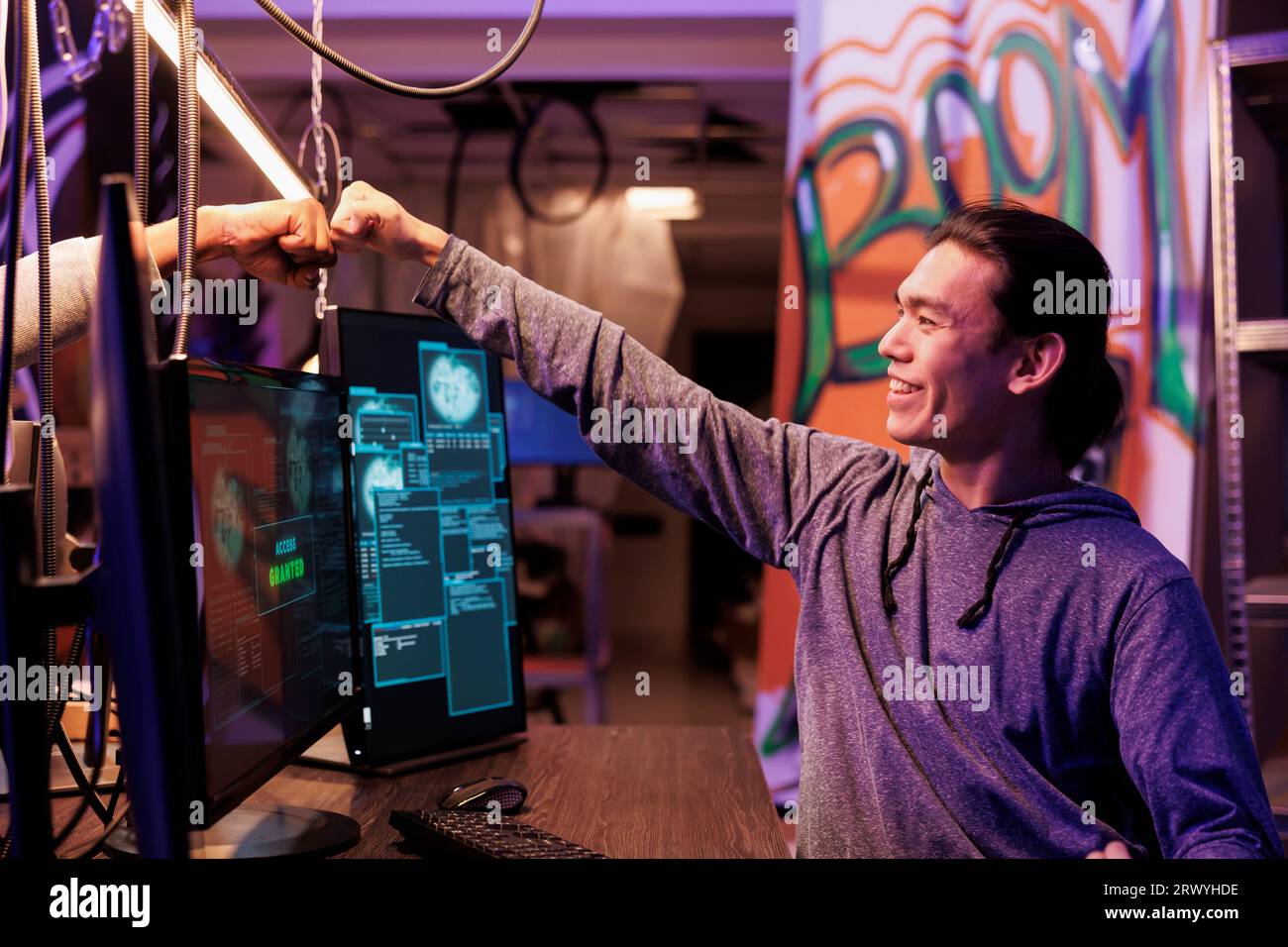 Happy hacker bumping fists with crime partner after breaking into server successfully. Cheerful ...