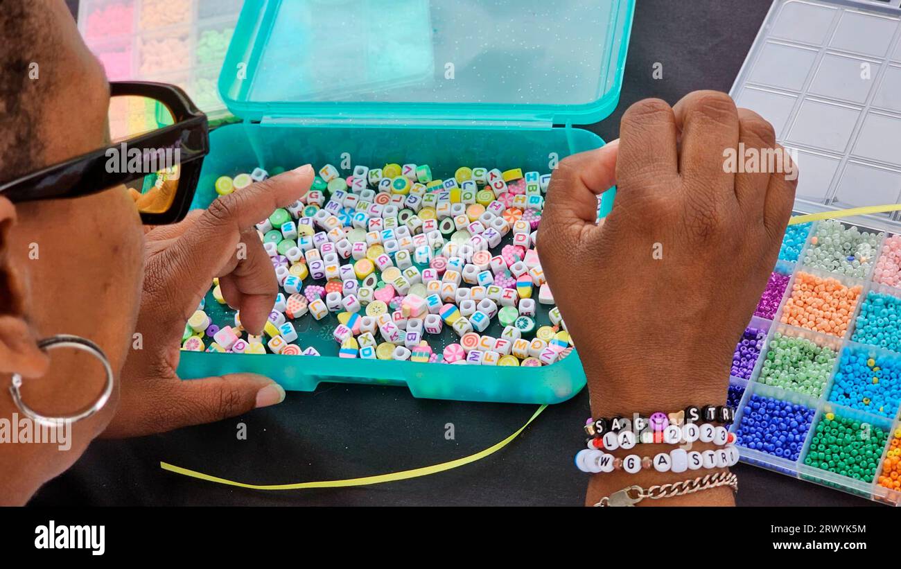 Writer Kimberly Alsup selects alphabet letter beads outside the gates ...