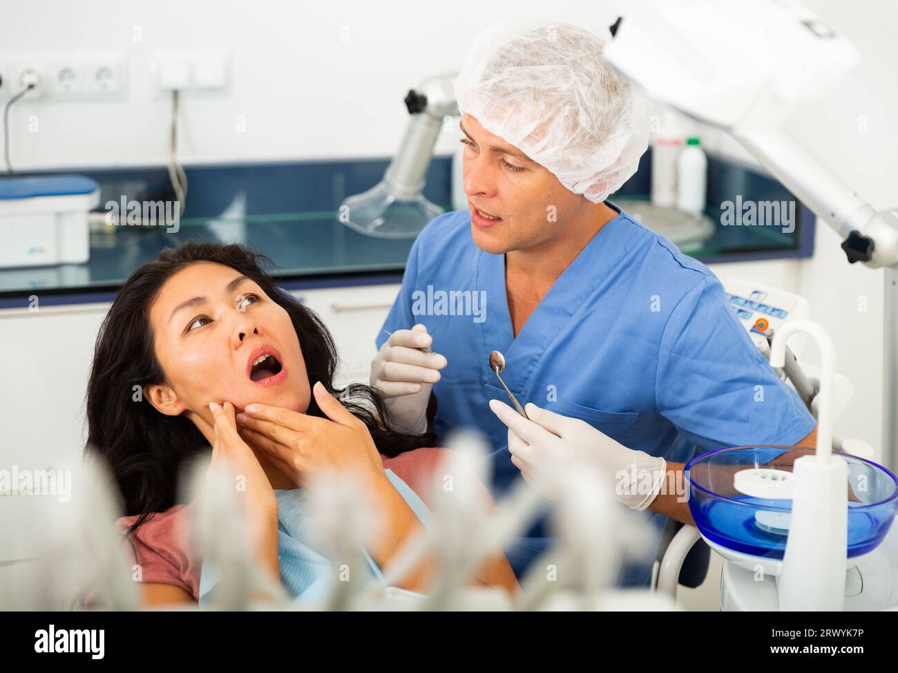 Female patient shows sick tooth to a dentist in dental clinic Stock ...