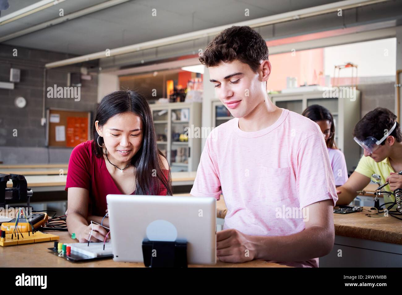 Multiracial boy and girl students at technical high school using a ...