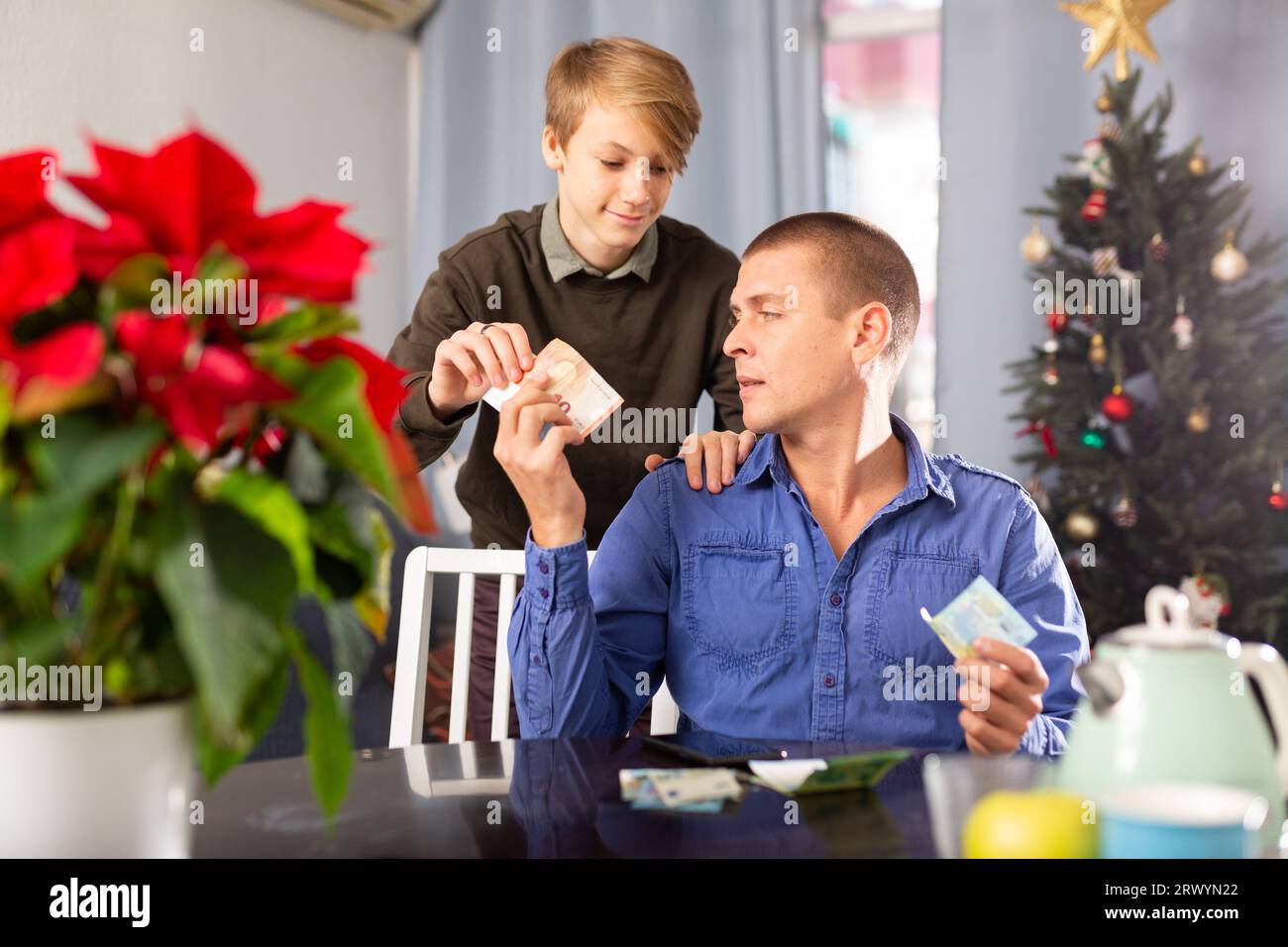 Father giving his teenage son money to celebrate christmas Stock Photo ...