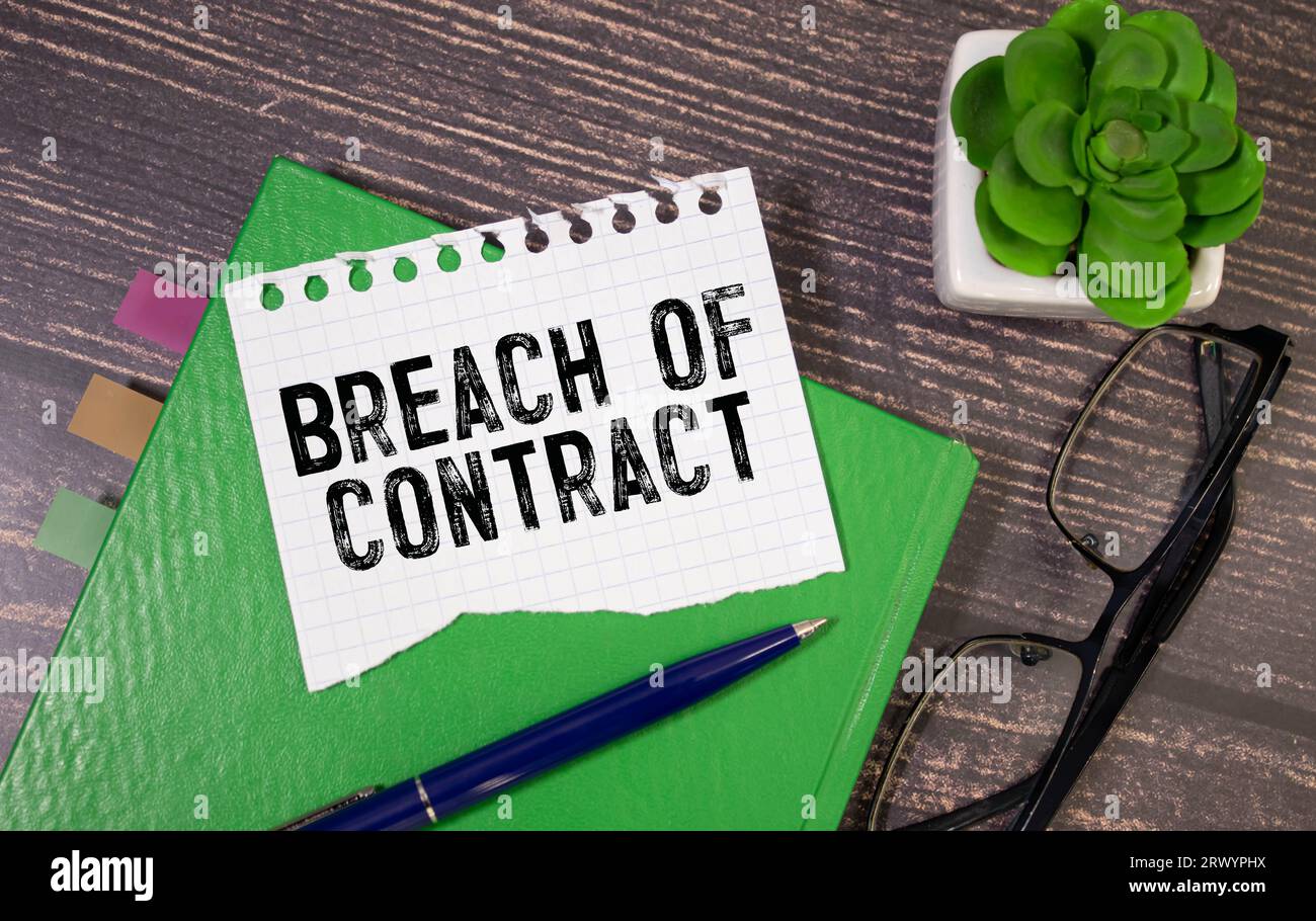BREACH OF CONTRACT. text in notepad next to glasses on white background ...
