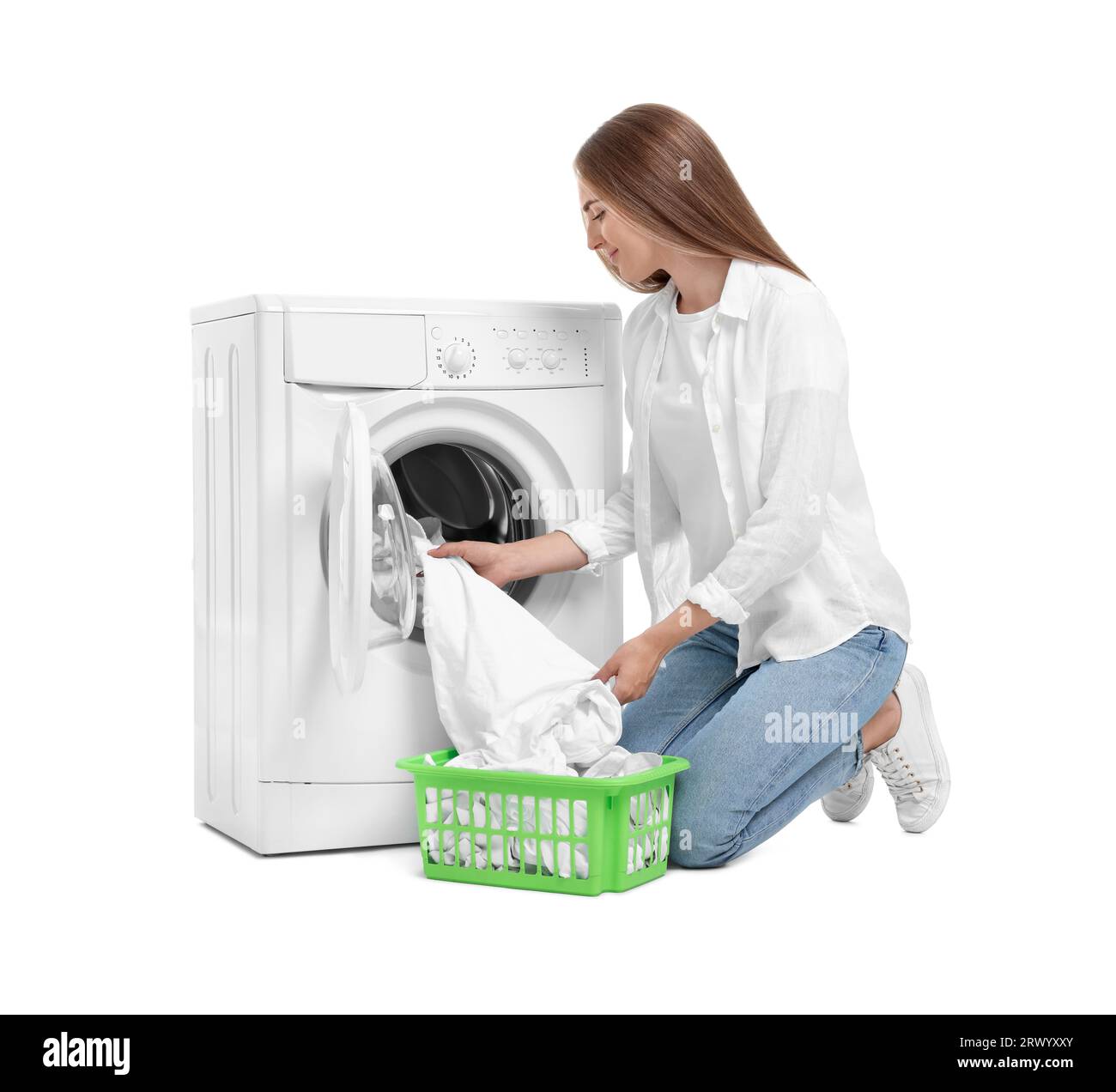 Beautiful young woman taking laundry out of washing machine on white ...