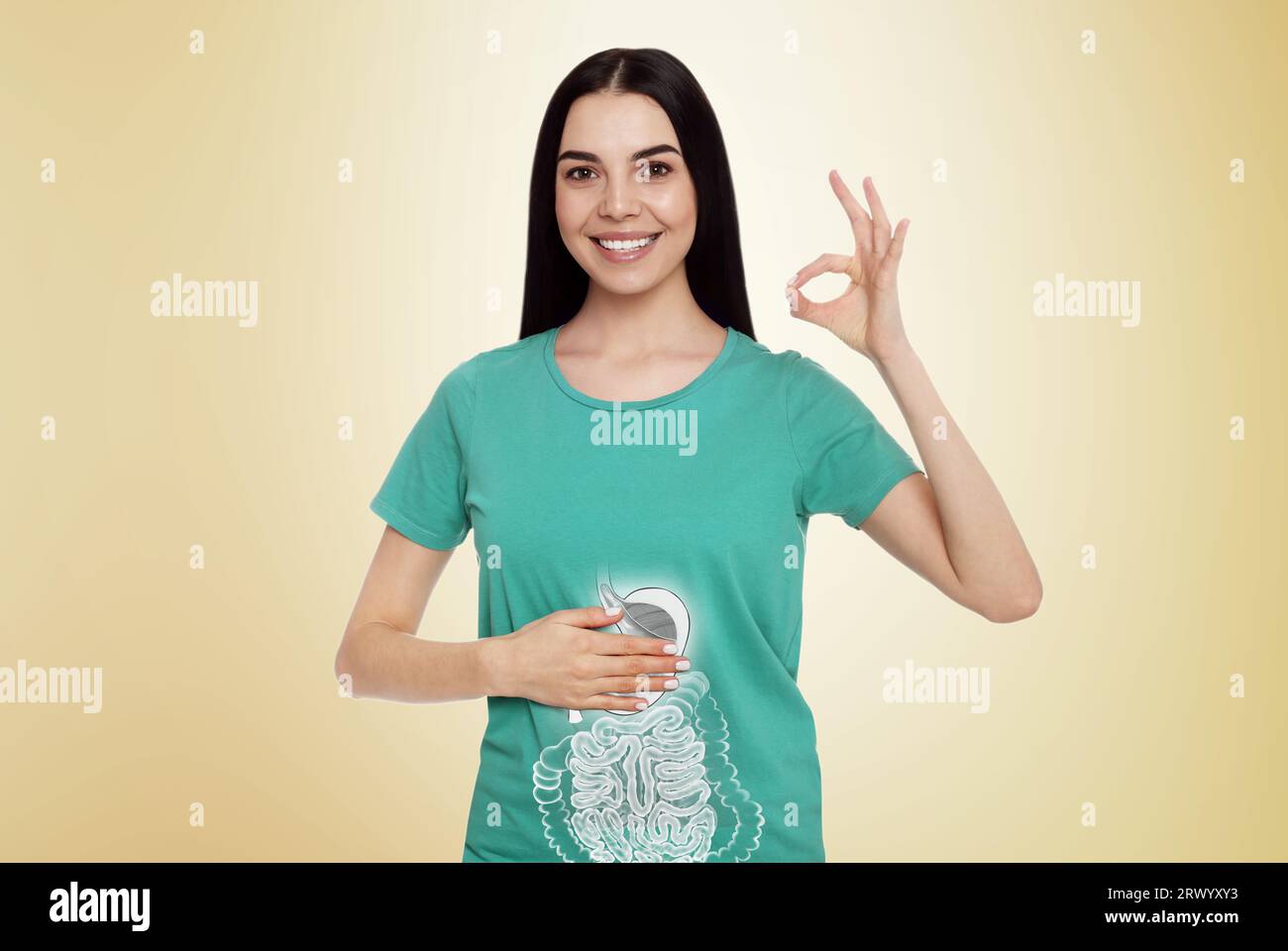 Happy woman with healthy digestive system on light yellow background ...