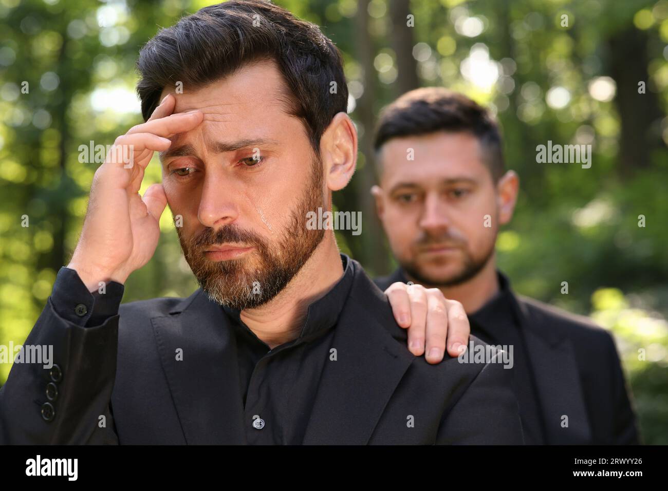 Funeral ceremony. Man comforting his friend outdoors Stock Photo - Alamy