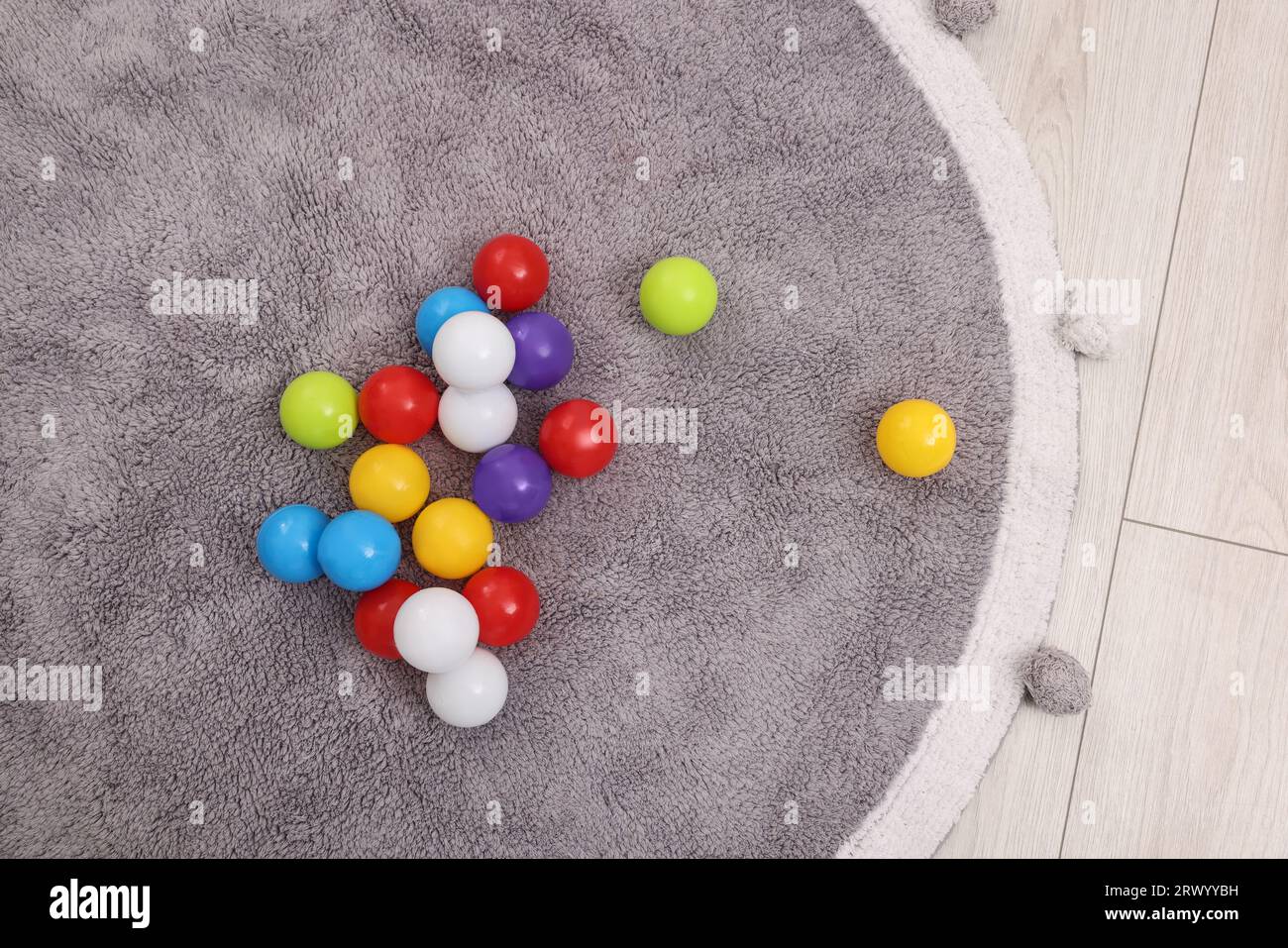 Bright toy balls and soft rug on floor in kindergarten, top view Stock ...