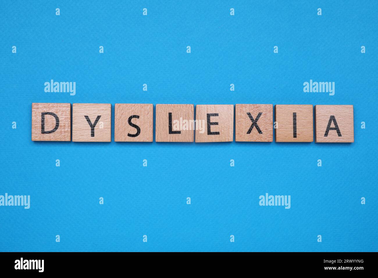 Wooden cubes with word Dyslexia on light blue background, flat lay ...