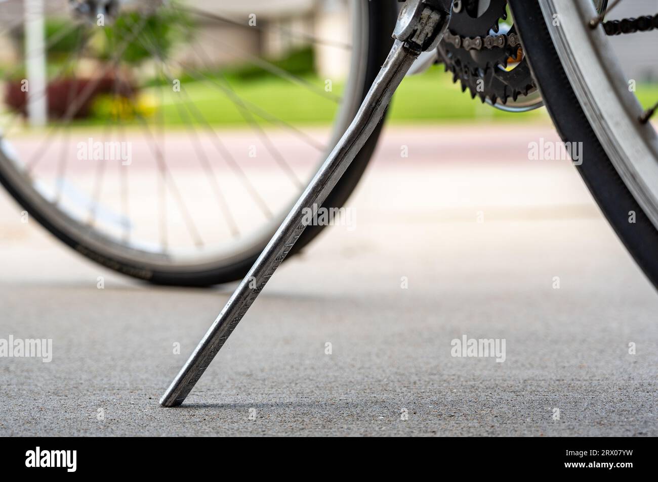 Kick stand holding up a peddle bike with blurred tire in background ...