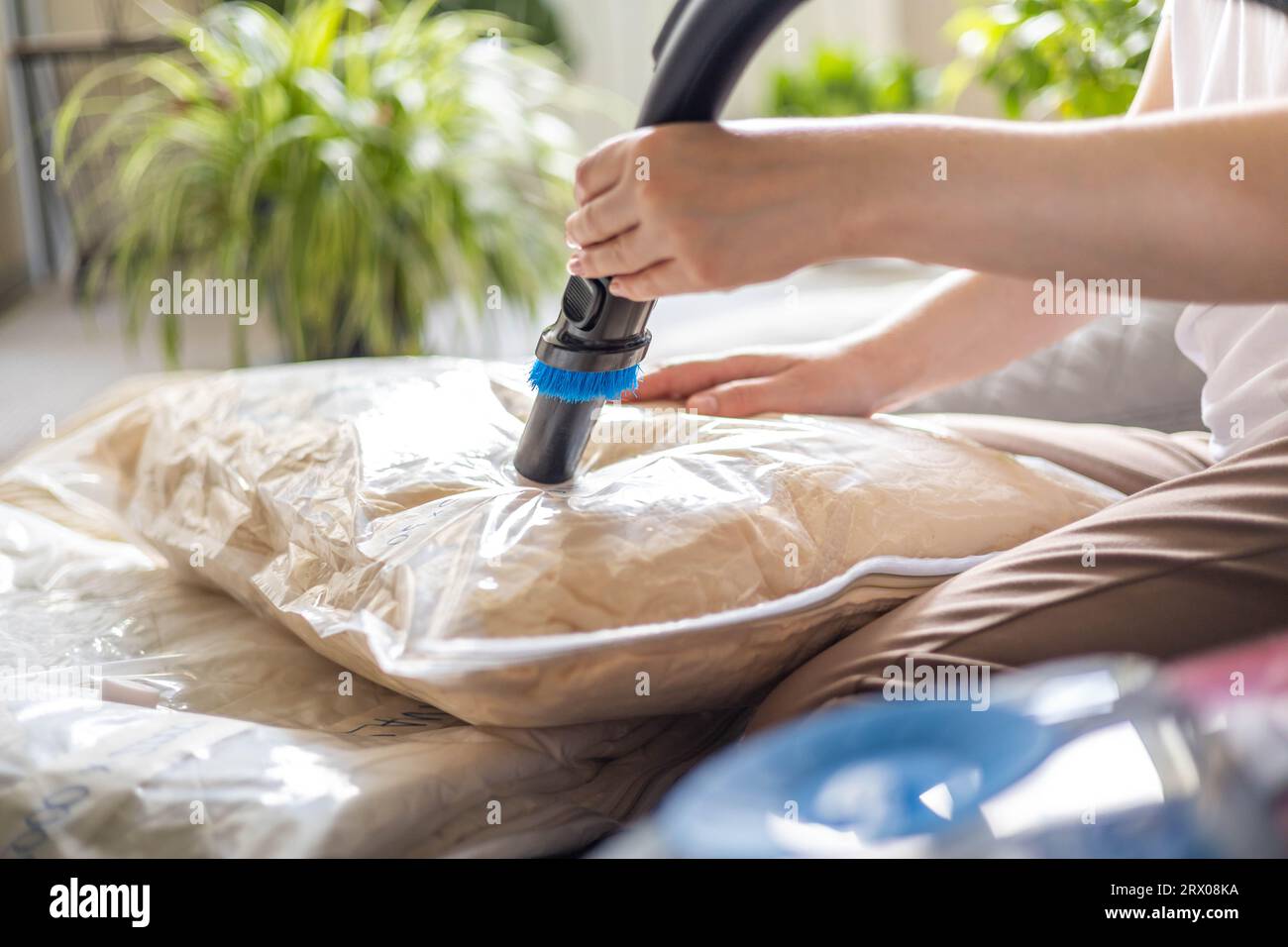 The girl pumps out air with a vacuum cleaner from a vacuum bag with ...