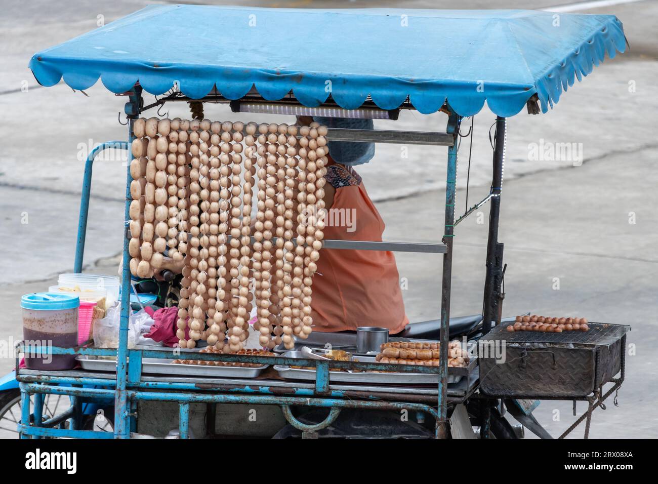 A woman drives a motorcycle with a sidecar modified for cooking ...