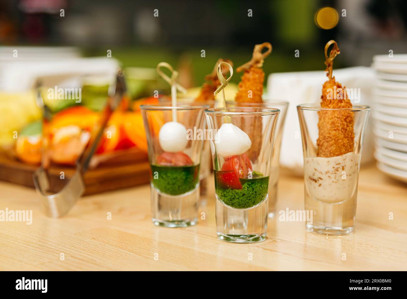 set of caprese canapes in shots, party snacks in glasses on a table in ...