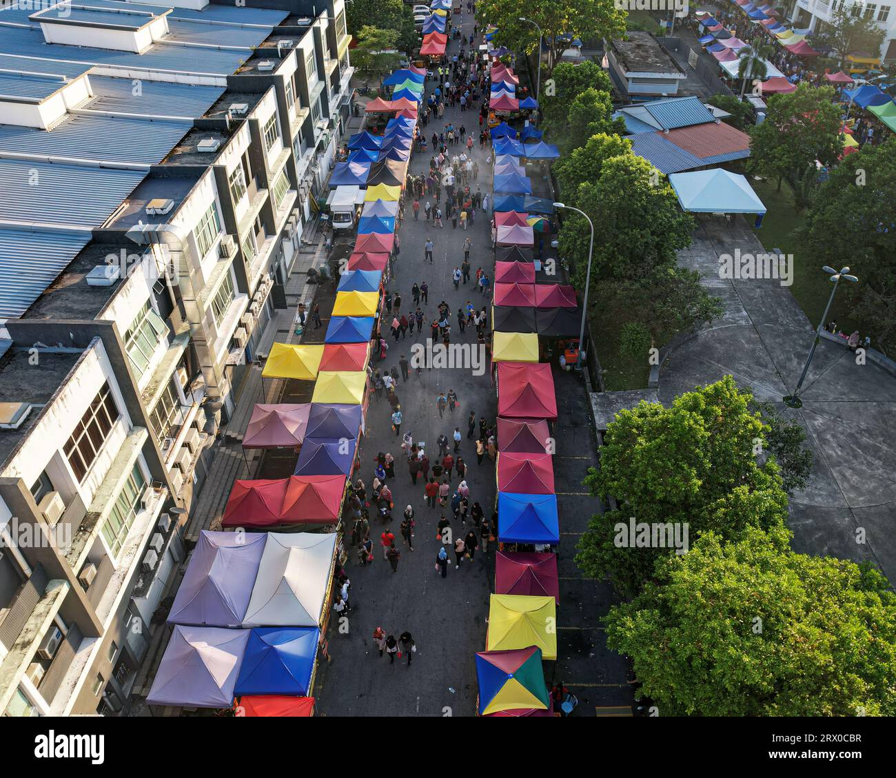 A vibrant display of market tents set up on a city street in front of ...
