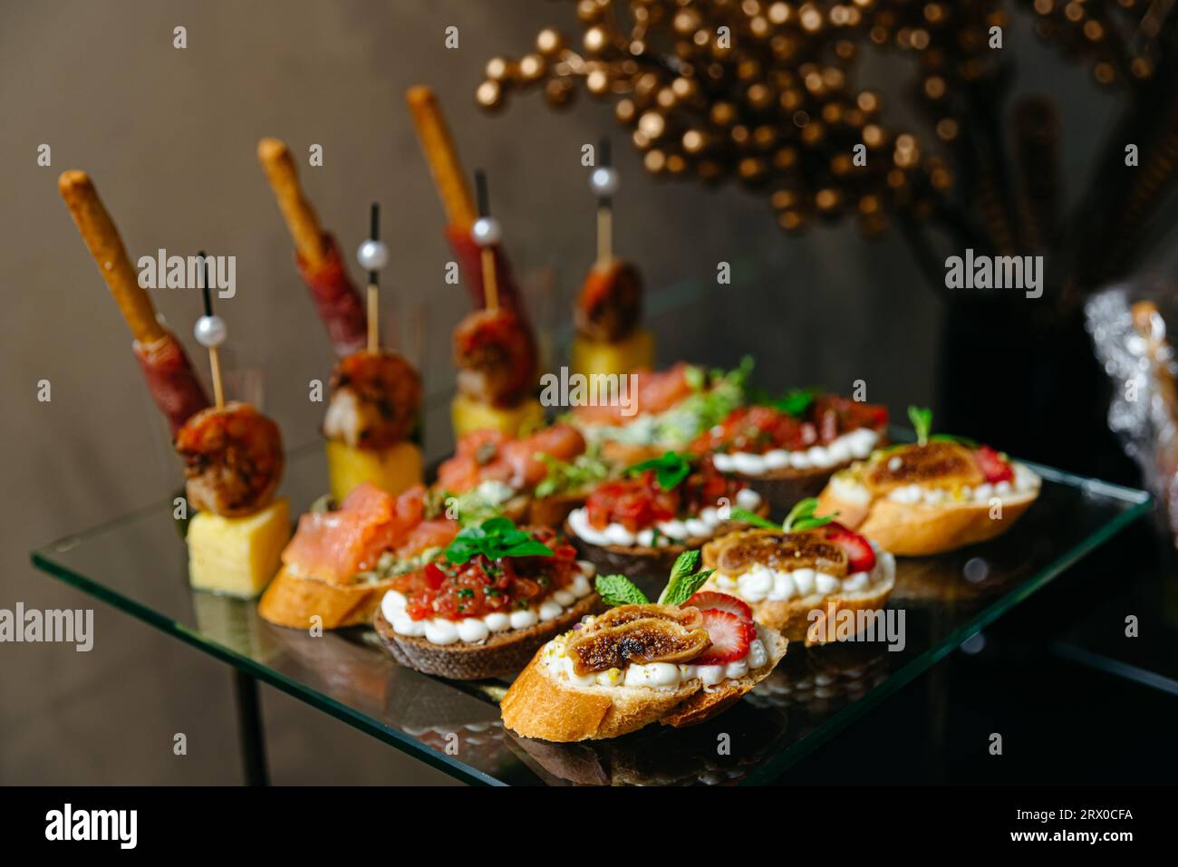 Canapes on a glass table. Canapes of different types of cheese, tartar ...
