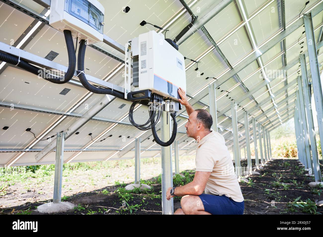 Male worker checking if solar inverter working right. Young man ...