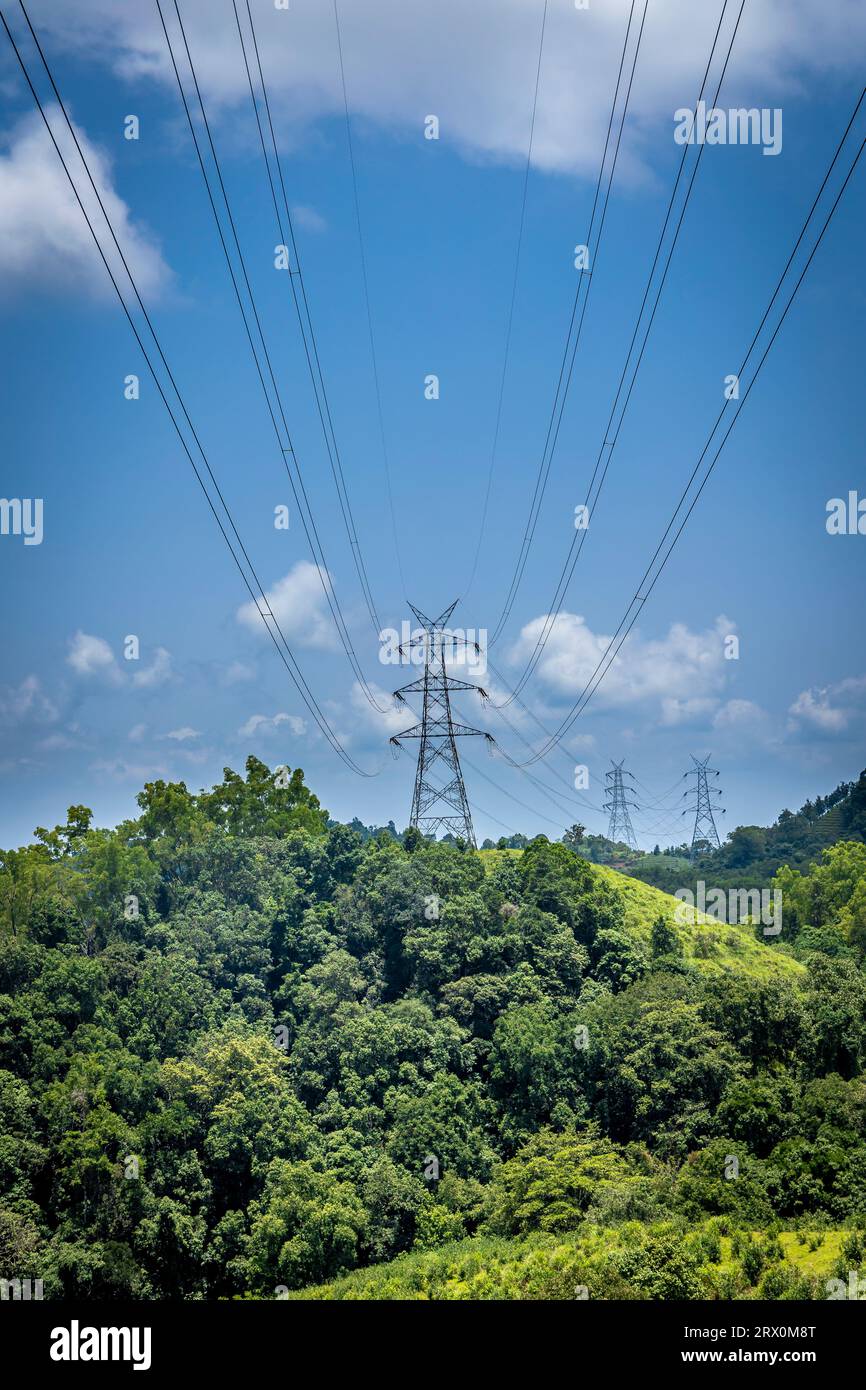 High voltage power, electrical lines running down valley landscape with ...